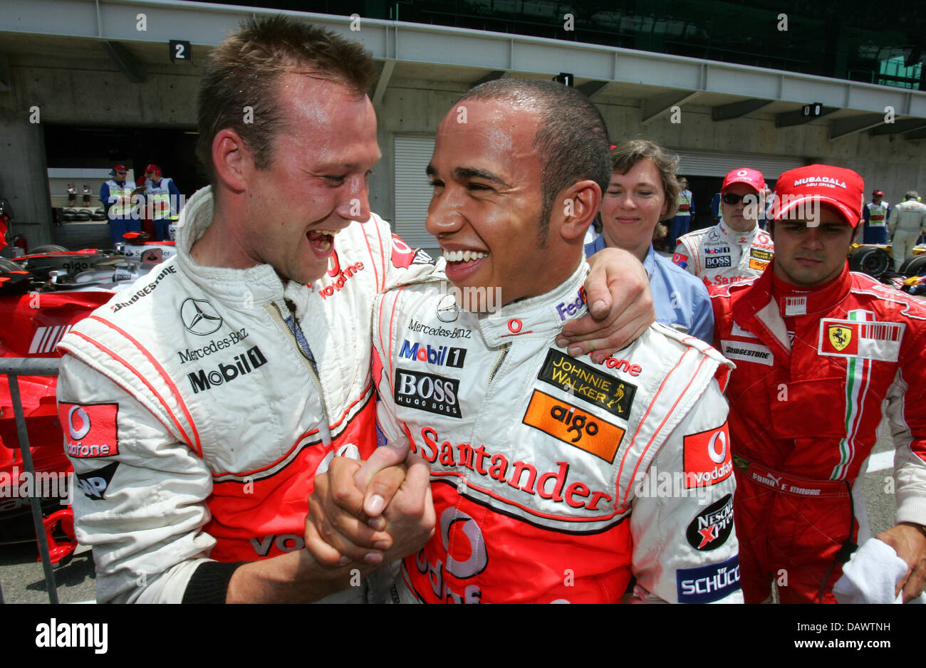 A McLaren Mercedes mechanic (L) cheers British Formula One rookie Lewis ...