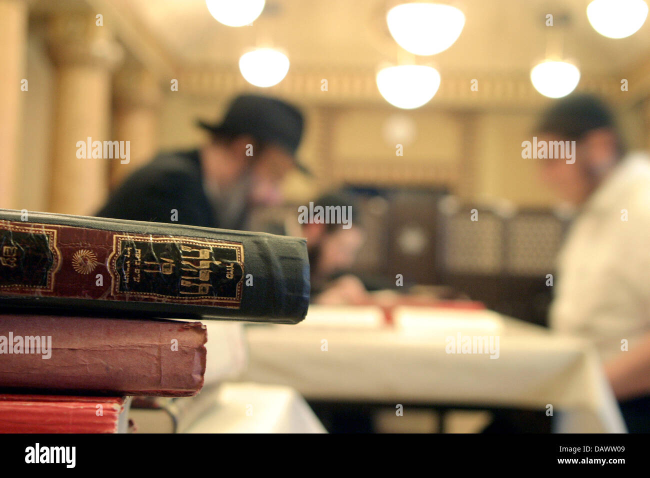 The picture shows a book in hebrew with studying students in the ...