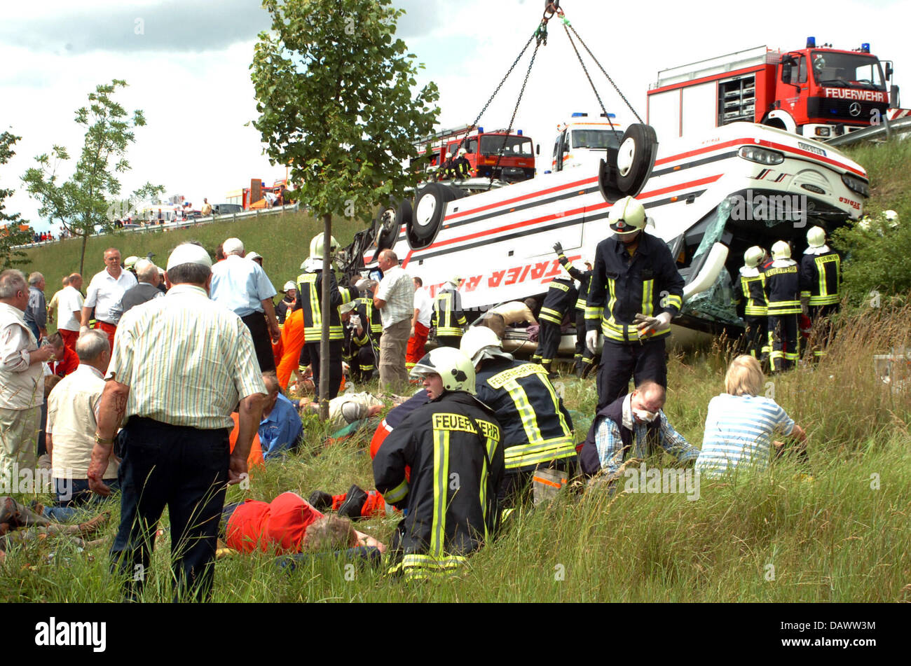 Firemen and emergency workers free persons from a crashed coach lying ...