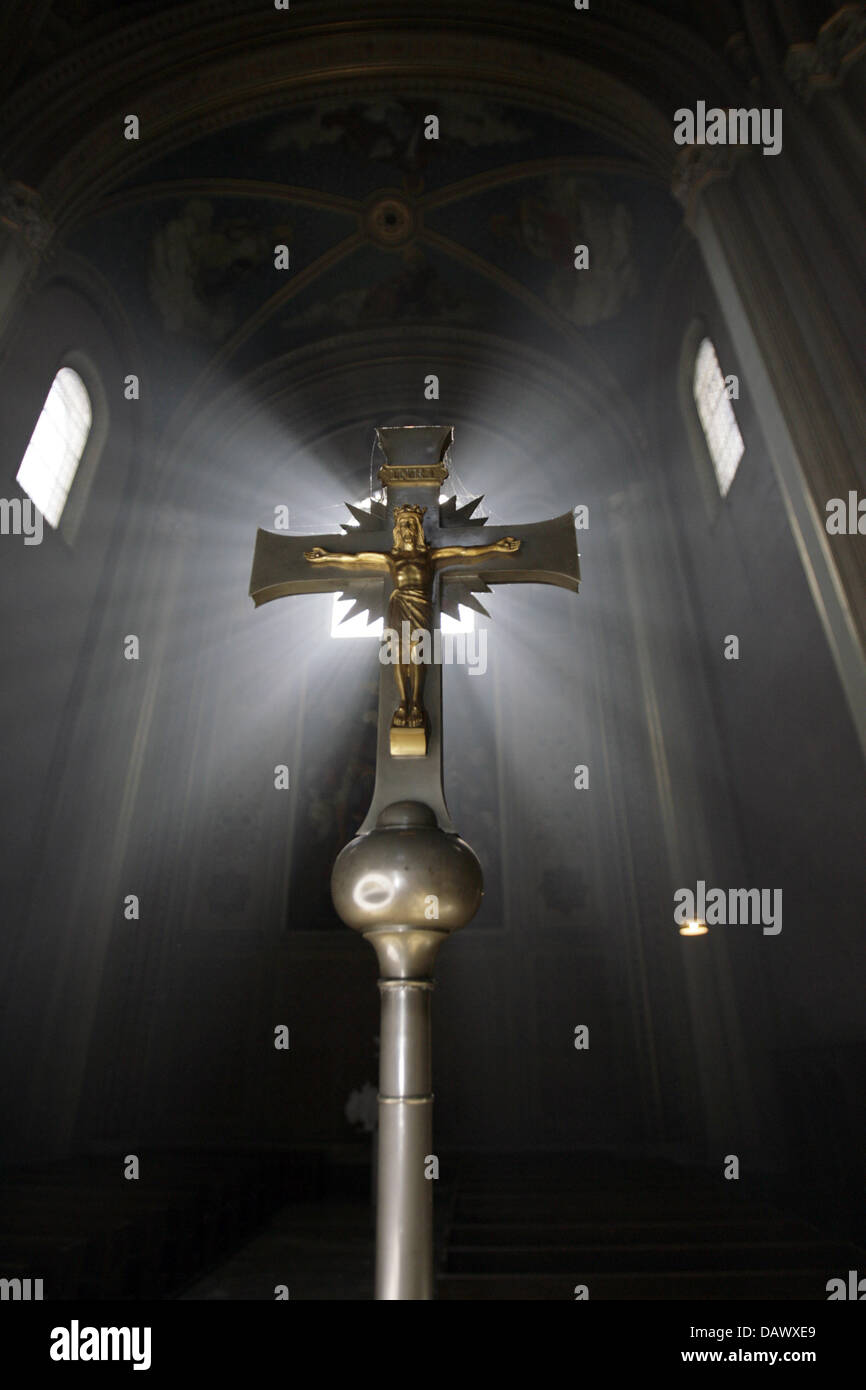 Sunlight illuminates a brazen cross with a Jesus-figure at the Catholic ...