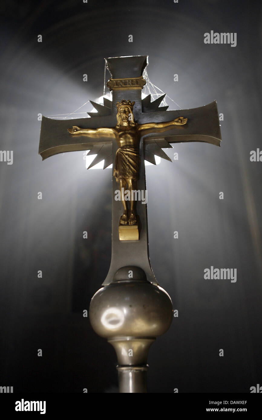 Sunlight illuminates a brazen cross with a Jesus-figure at the Catholic ...