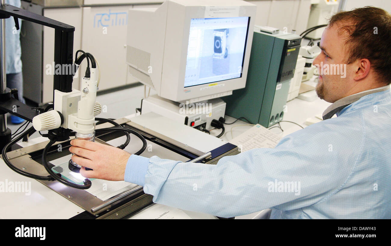 An employee of Siemens controls new rape boards in a white room of the ...