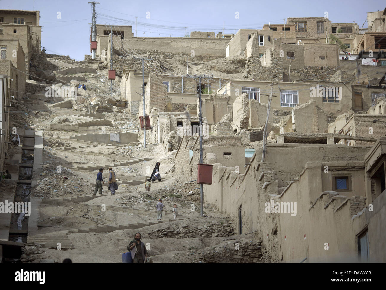 People descend the stairs of a steep slope covered with rubble between ...