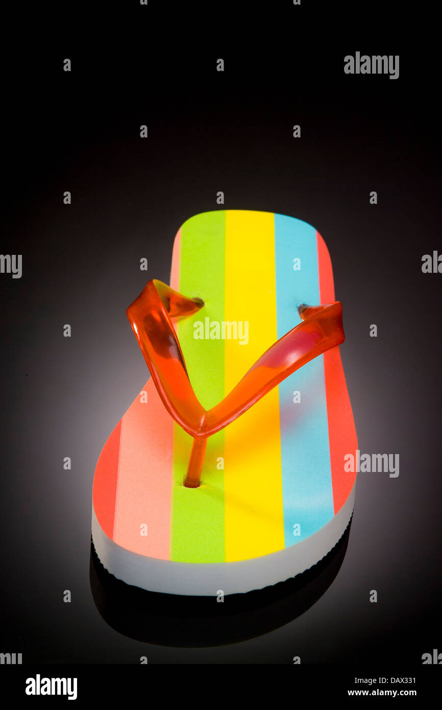 Single colour striped flip flop with red v shaped strap on a black ...