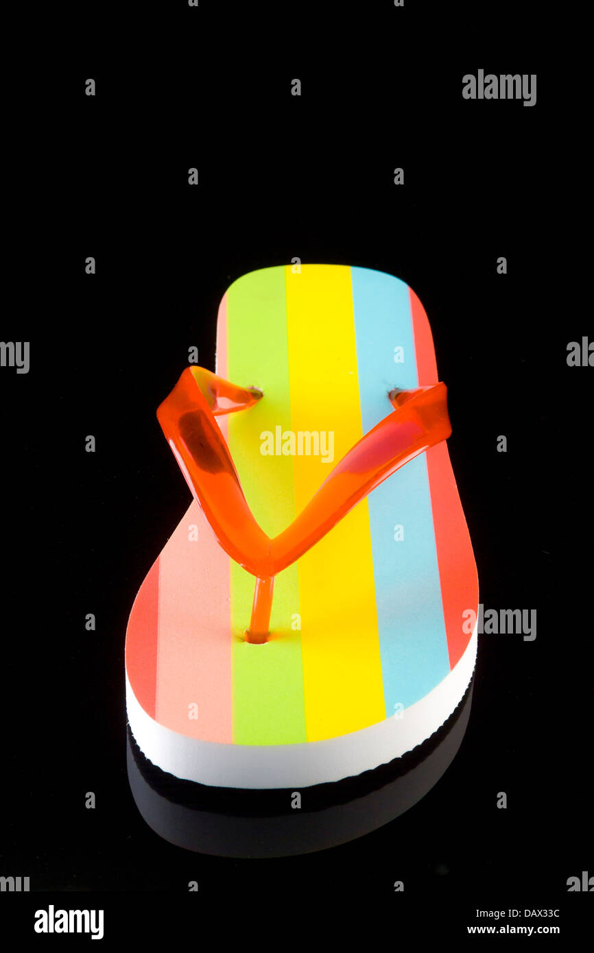 Single colour striped flip flop with red v shaped strap on a black ...