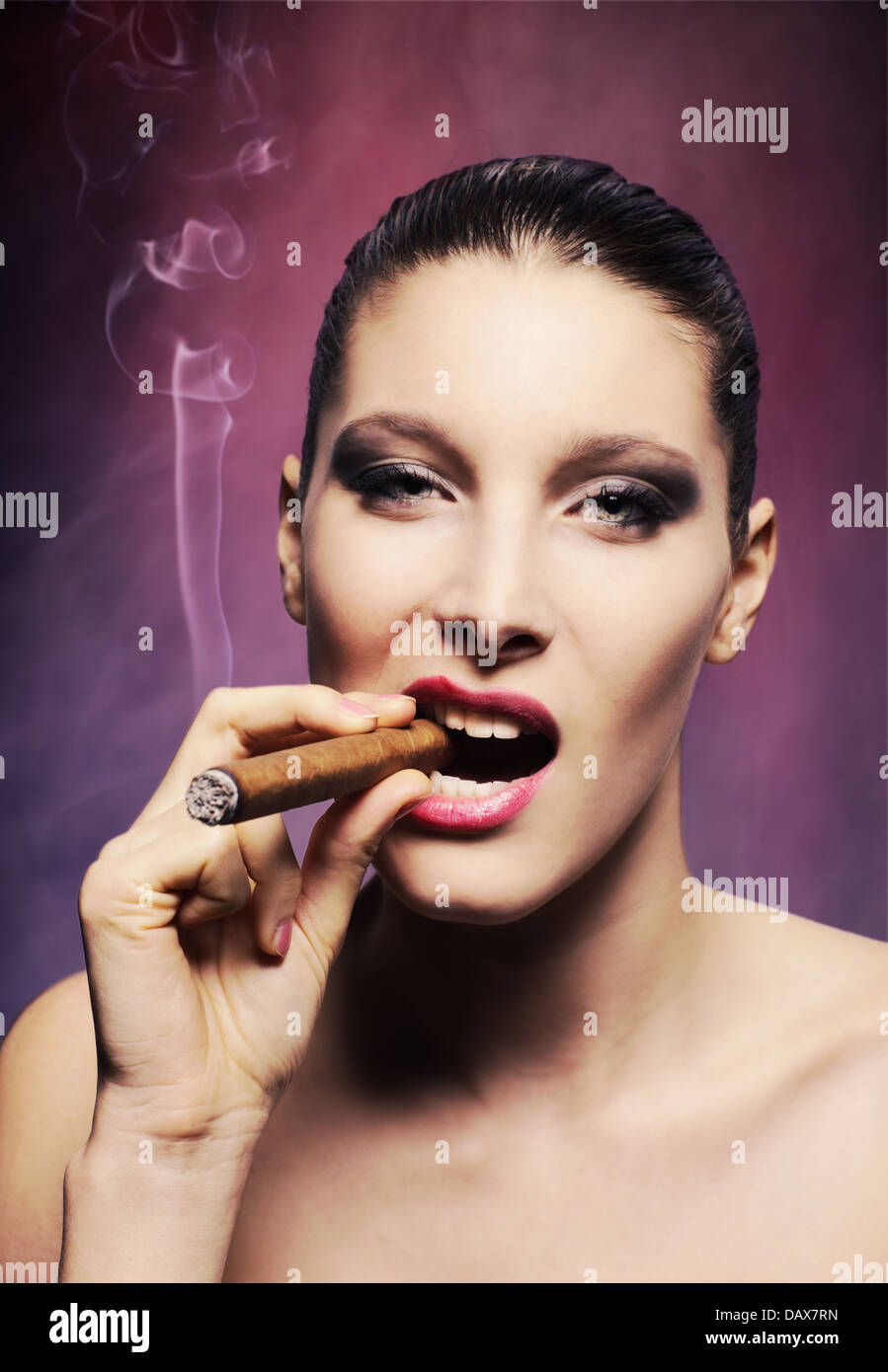 Attractive young woman smoking a cigar Stock Photo - Alamy