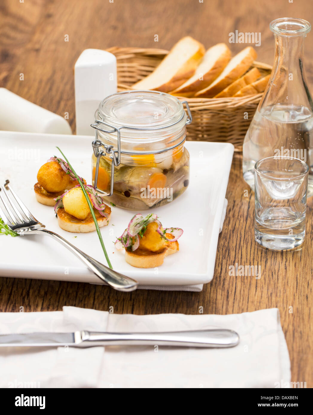 pickled herring in a glass jar with potato canapes Stock Photo - Alamy