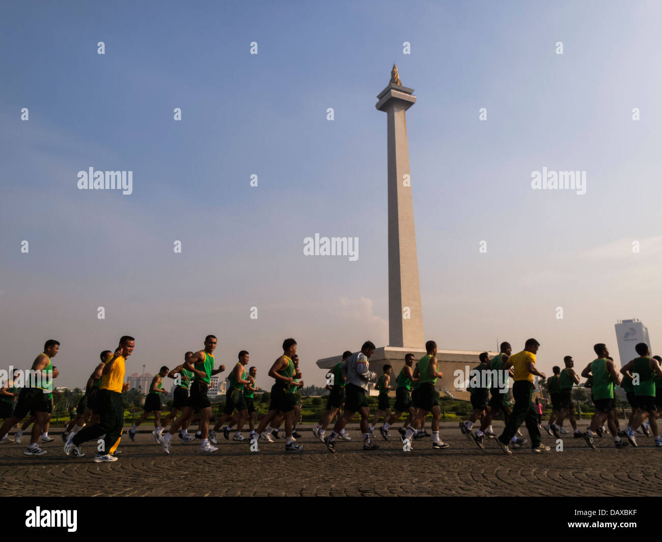 View of many men running around the National Monument in Merdeka Square ...