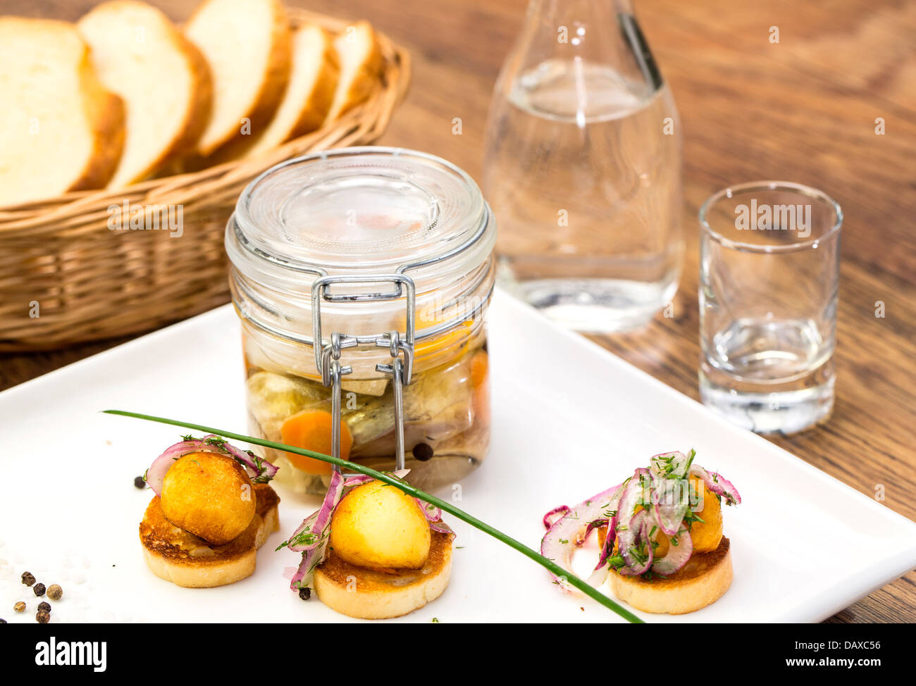pickled herring in a glass jar with potato canapes Stock Photo - Alamy