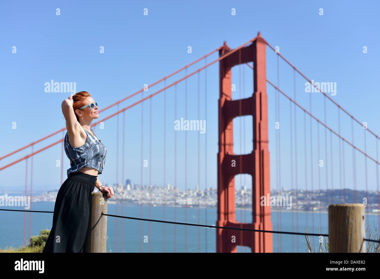 Redhead woman posing by Golden Gate Bridge Stock Photo - Alamy