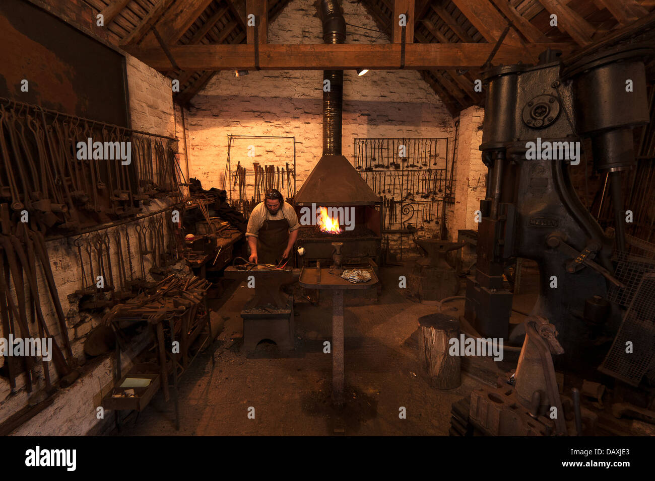 Modern Blacksmith forging red hot wrought iron on an anvil in his ...