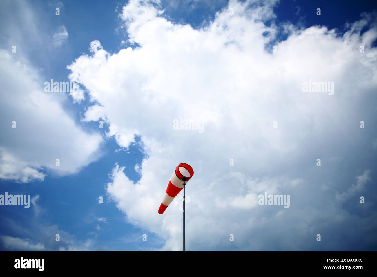 A red wind vane against a blue cloudy sky Stock Photo - Alamy