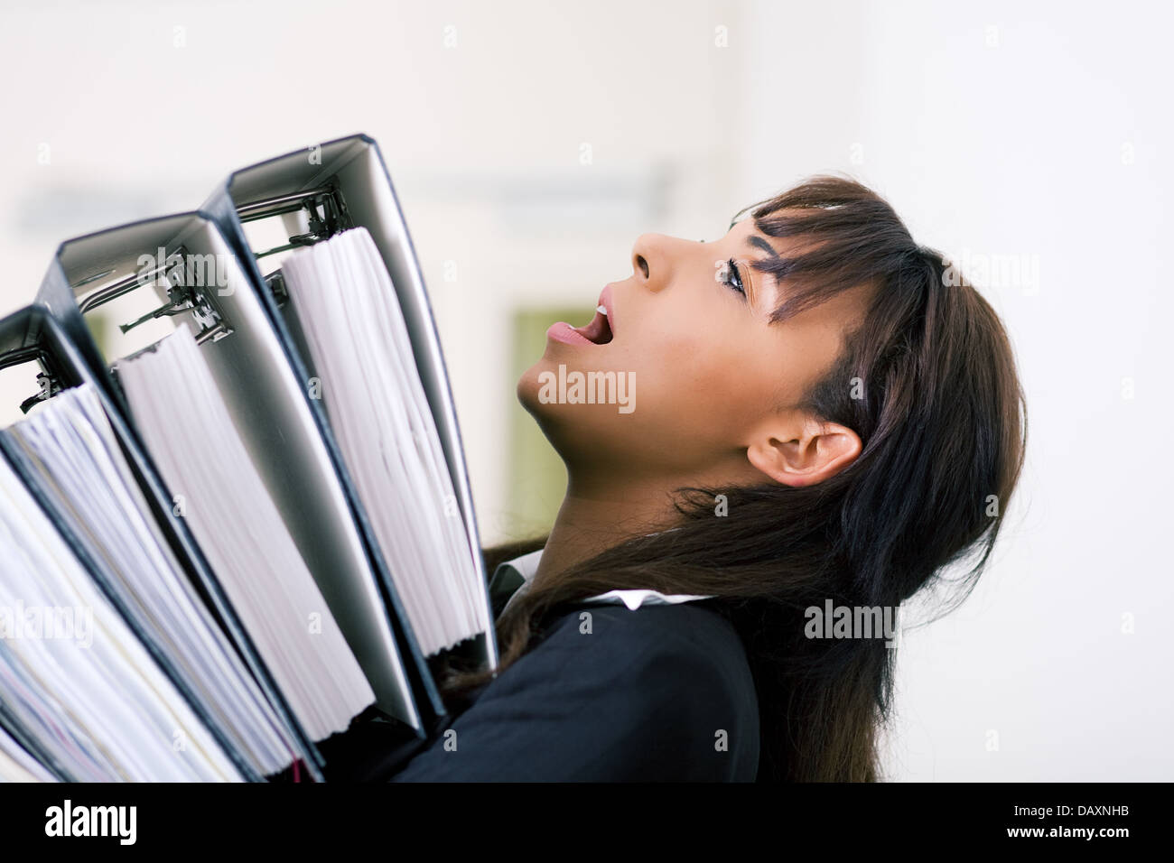 Secretary carrying more files that she can handle Stock Photo - Alamy
