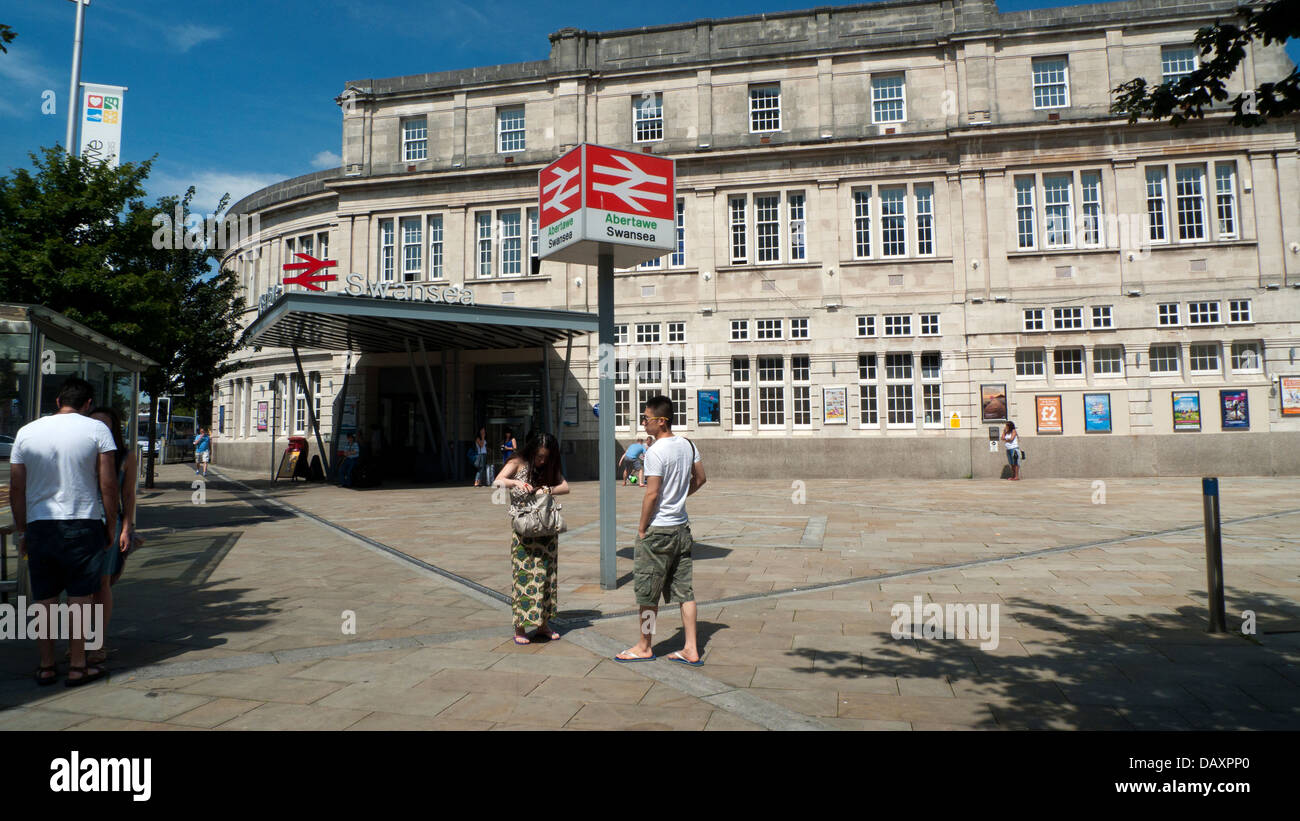 A young Asian couple standing outside Swansea train station forecourt ...