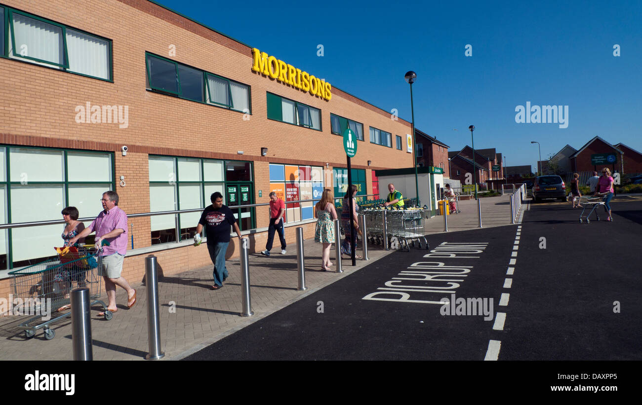 A Morrisons supermarket worker putting shopping trolleys away outside ...