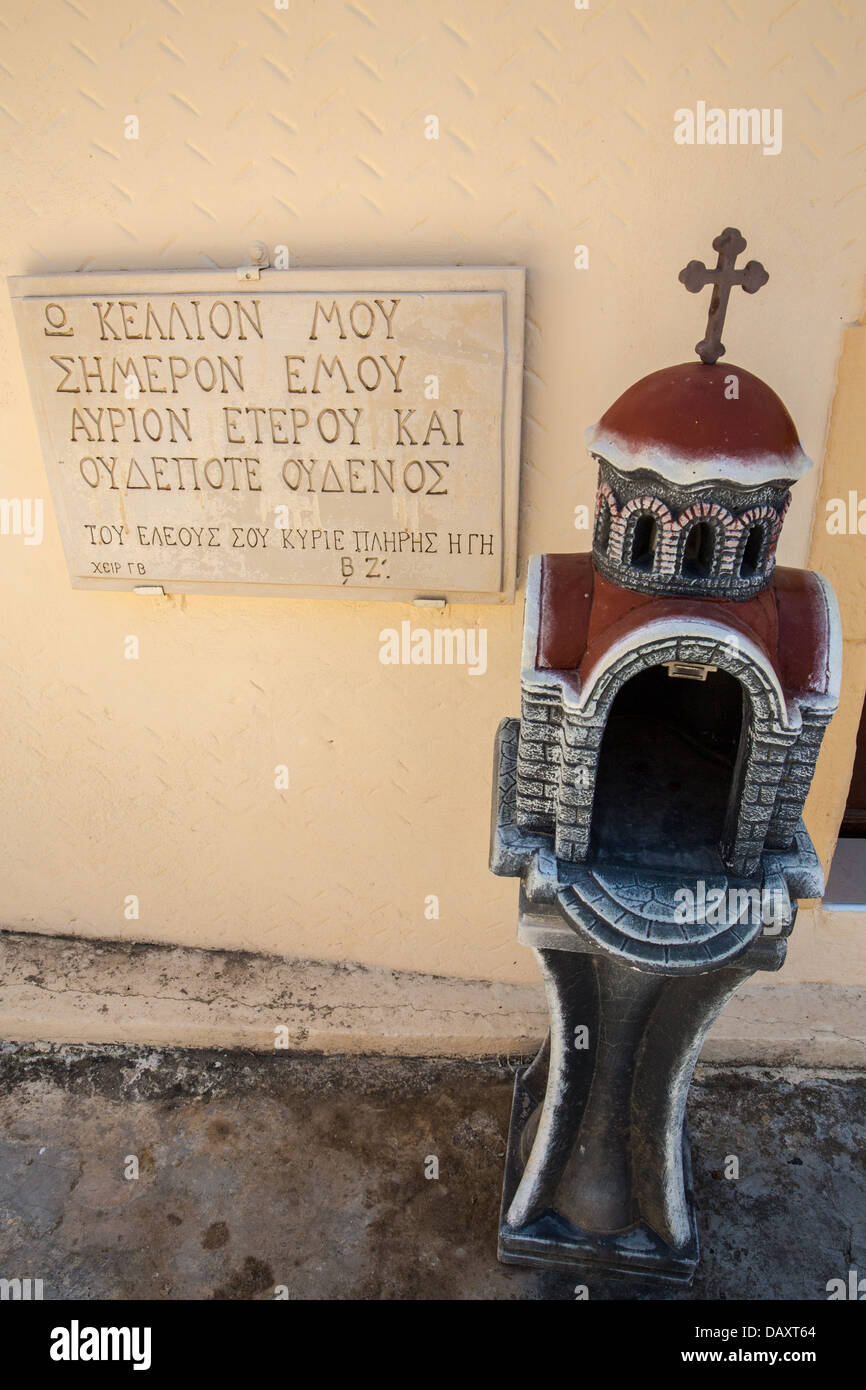 Greek religious symbol,cross,plaque with the name on wall of monastery ...