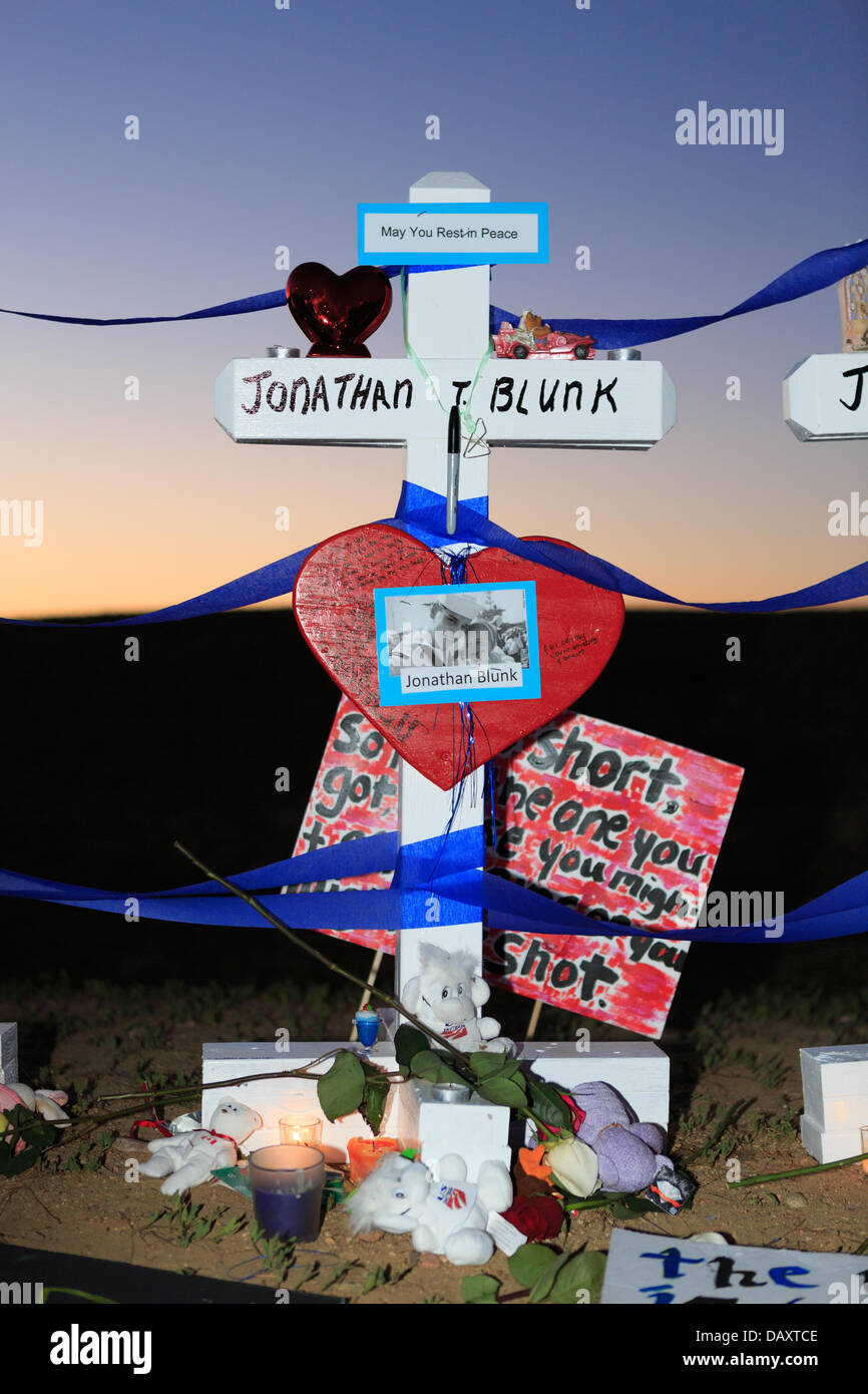 Aurora, Colorado, 20th July. The sun rises over a cross planted for ...
