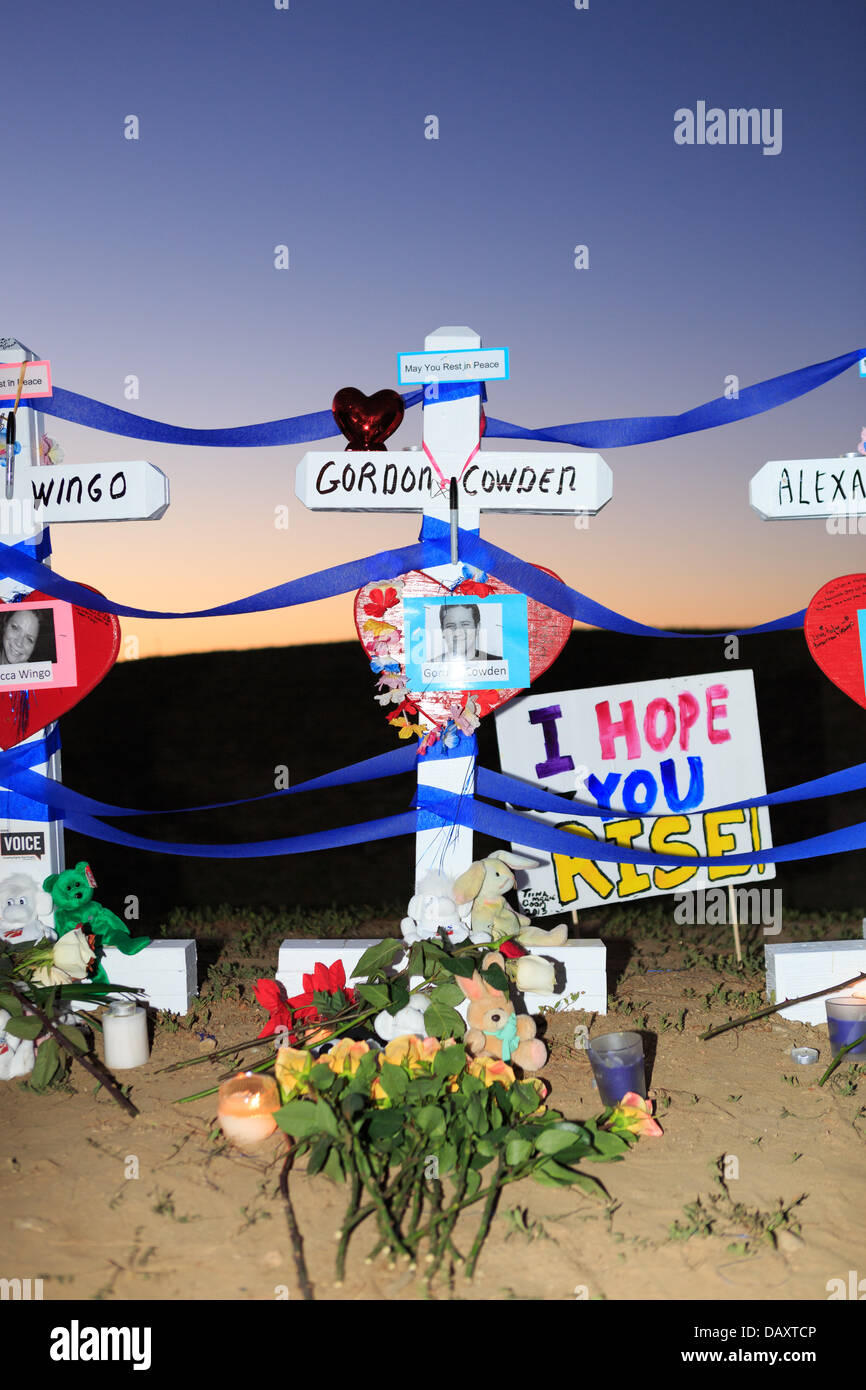 Aurora, Colorado, 20th July. The sun rises over a cross planted for ...