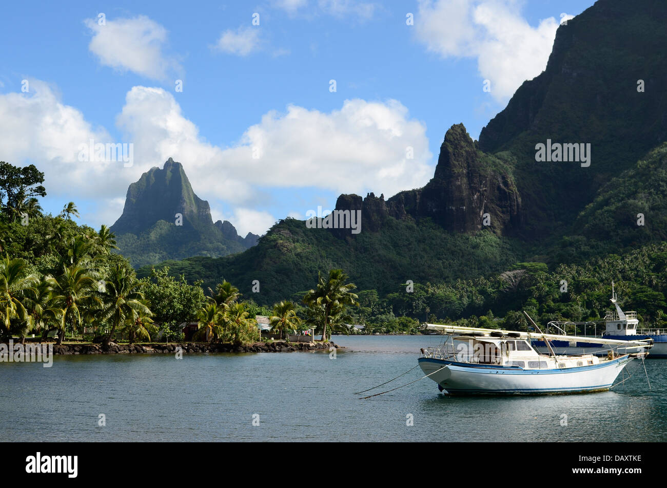Boat in Cooks Bay with Moua Puta mountain on the tropical pacific ...