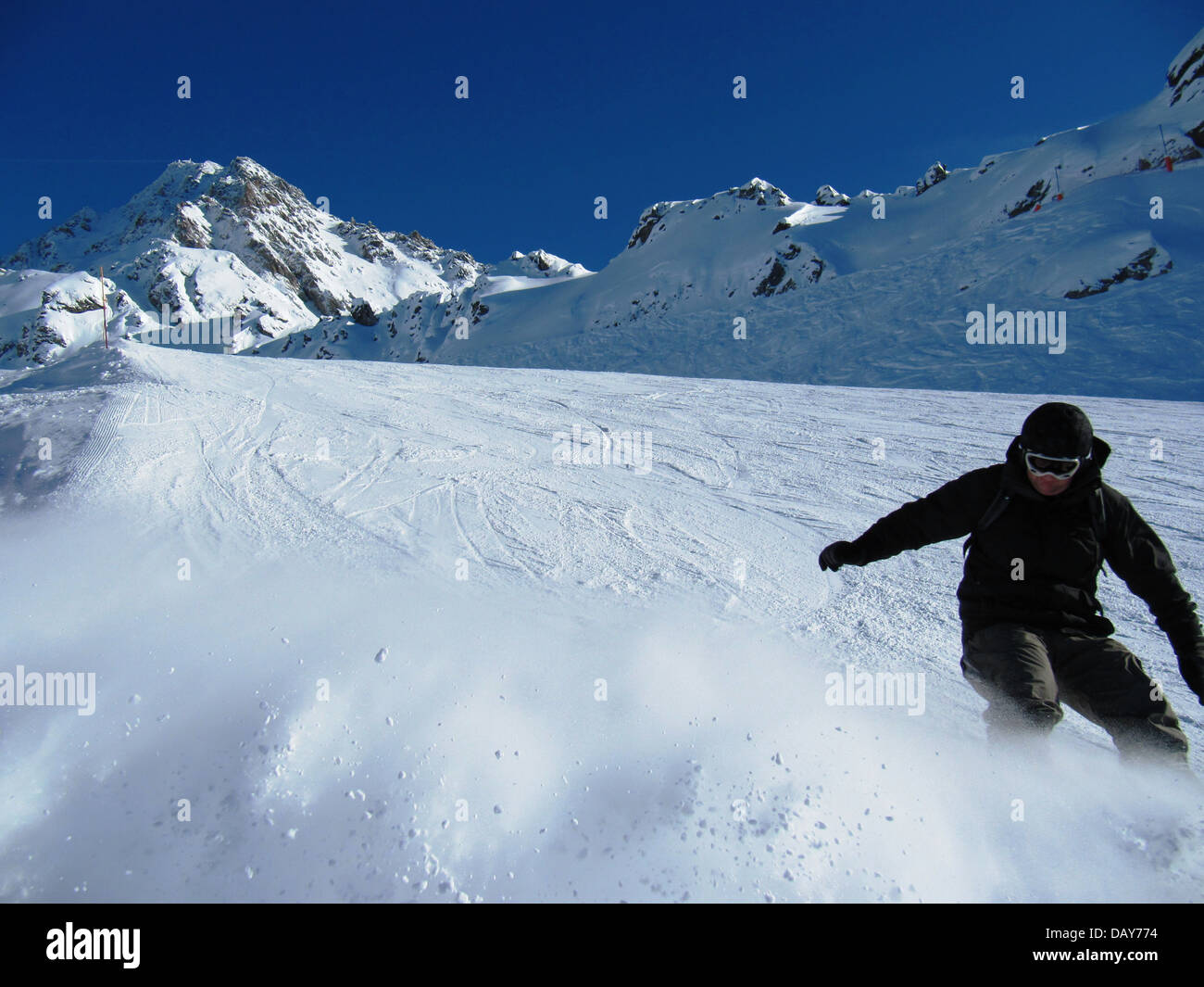 Snowboarder kicking up powder on a piste Stock Photo - Alamy