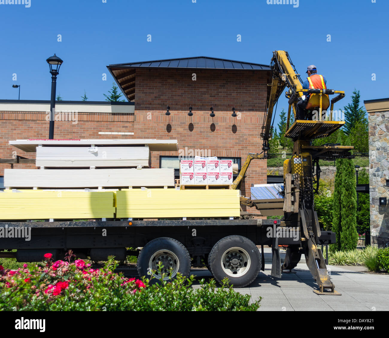 Contractor placing drywall sheets in a building under construction ...