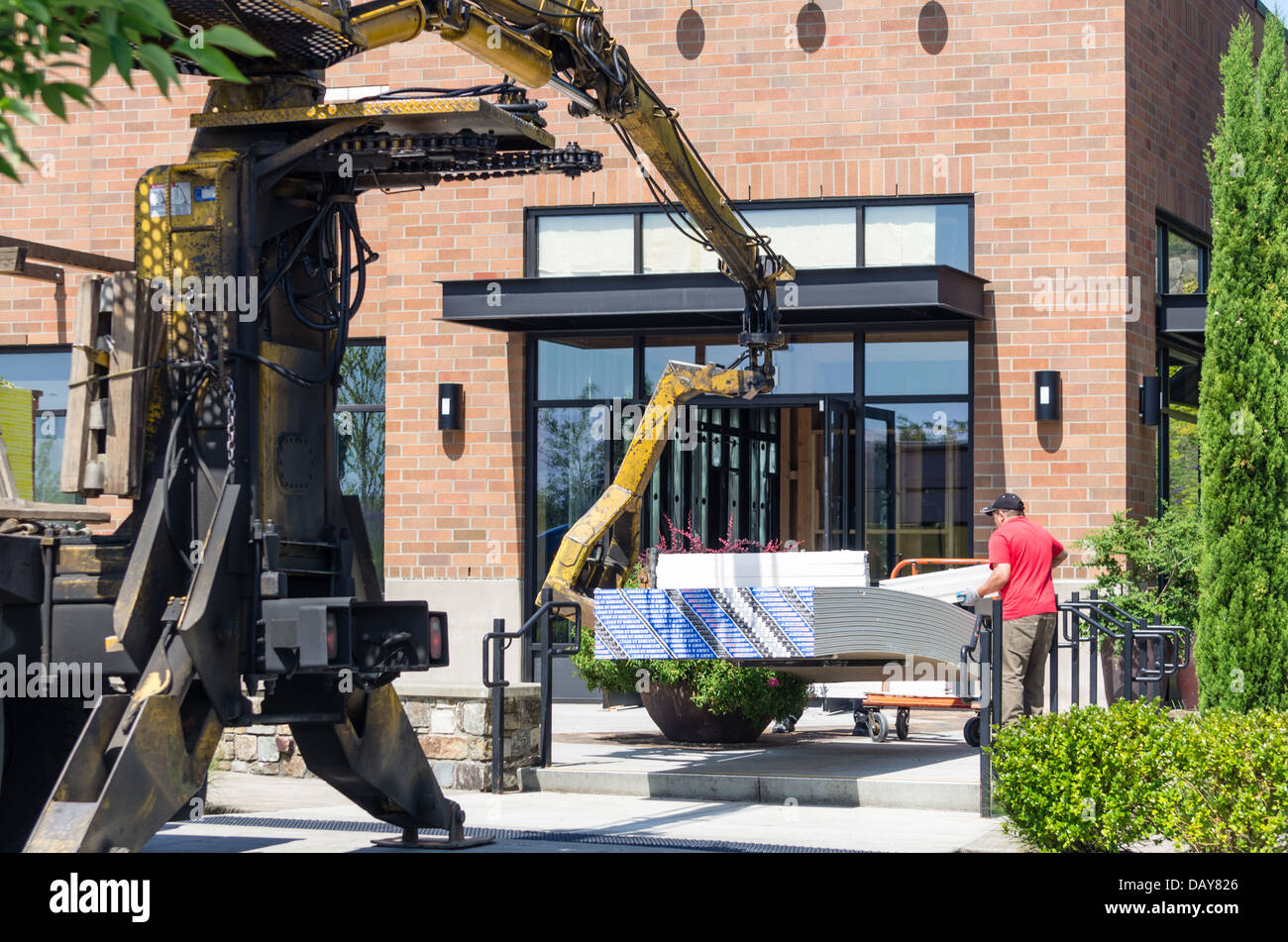 Contractor placing drywall sheets in a building under construction ...