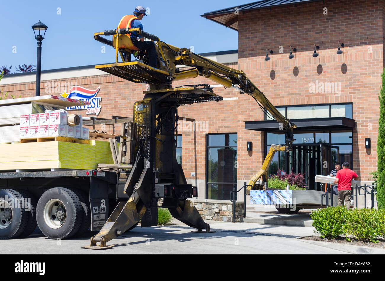 Contractor placing drywall sheets in a building under construction ...
