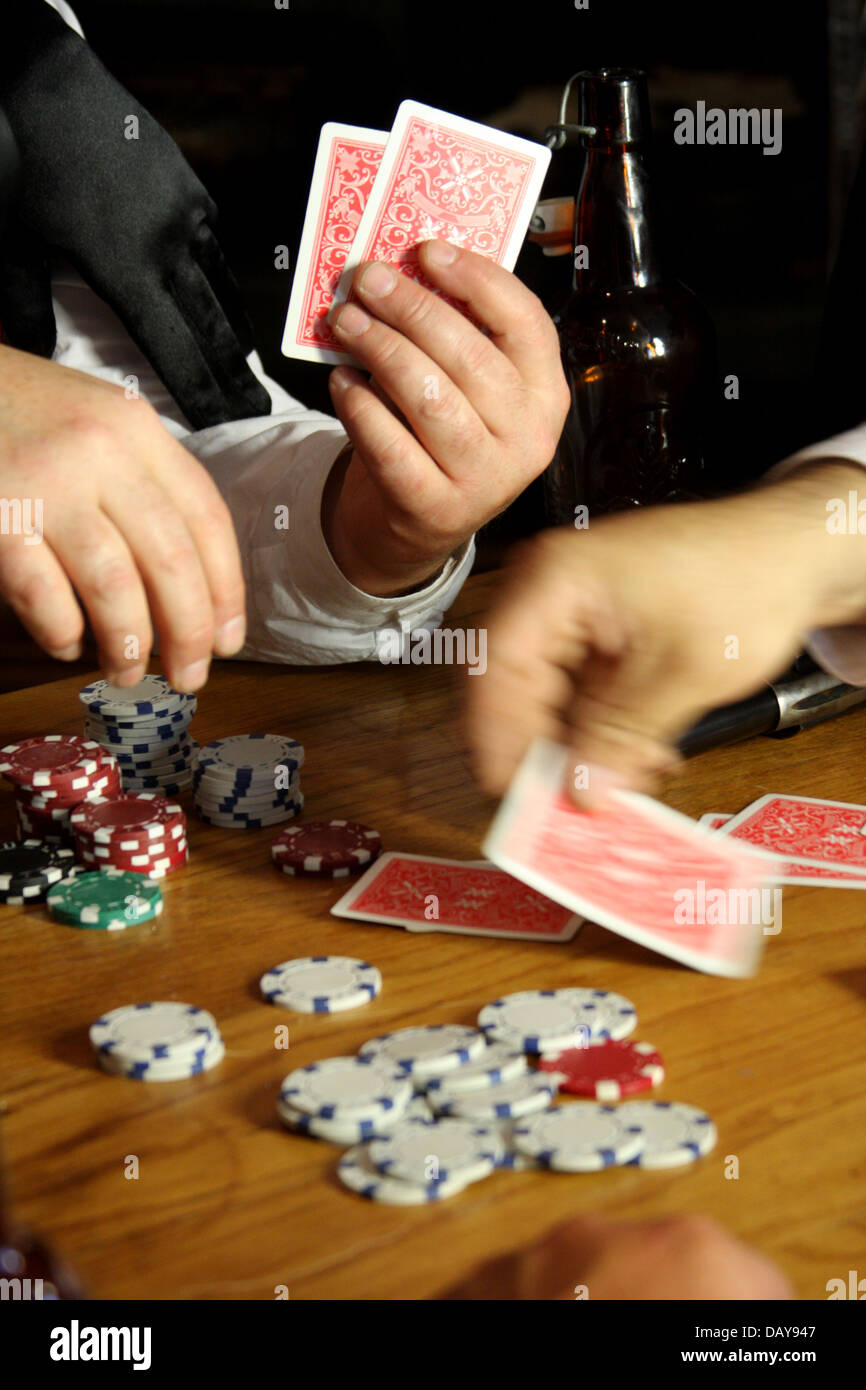 Men placing cards down on the table during an old west poker game Stock ...