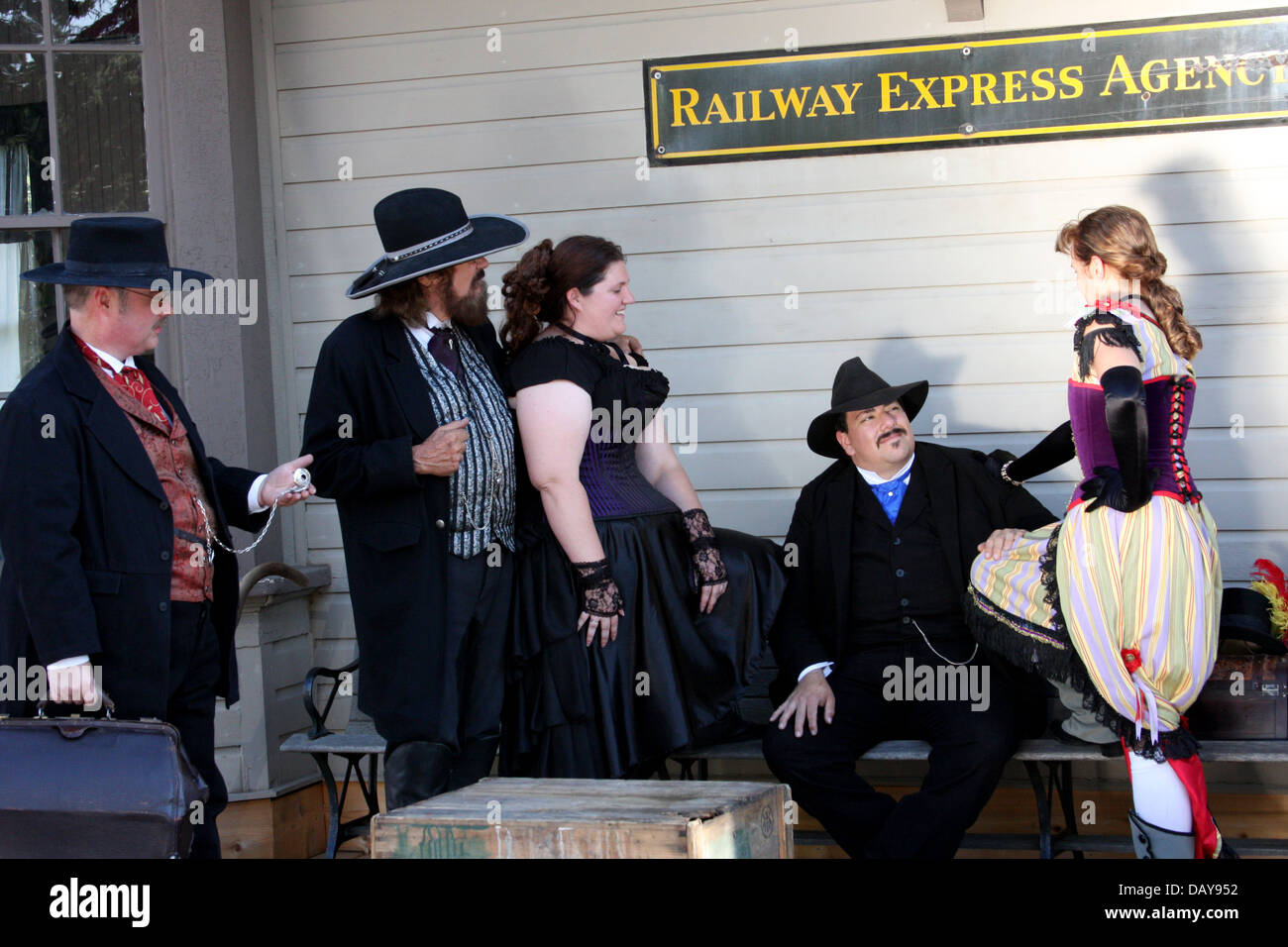 Western adults waiting on the train depot platform of a historical ...
