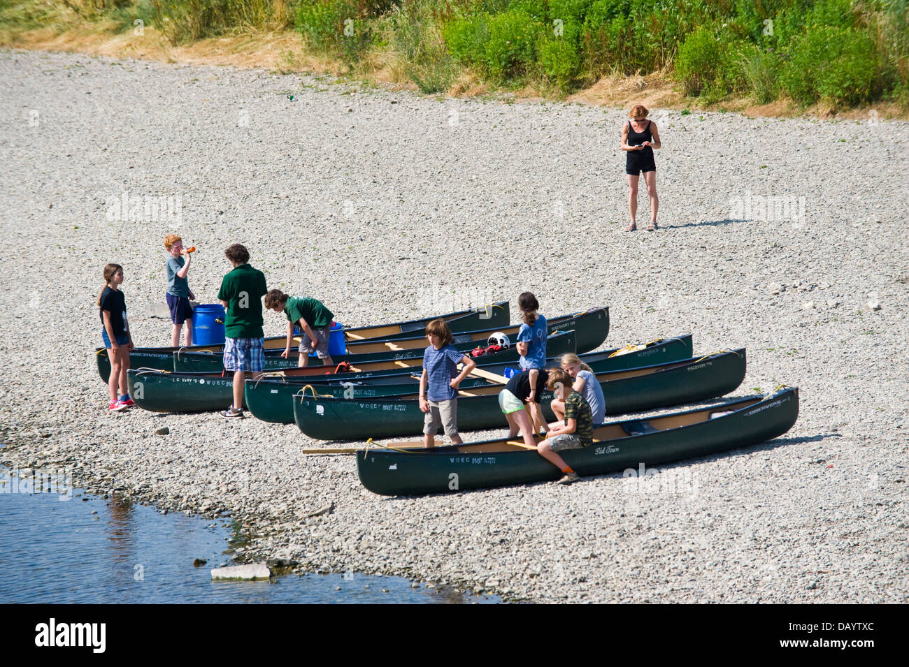 Groups of children receiving instruction in paddling open canoes on ...