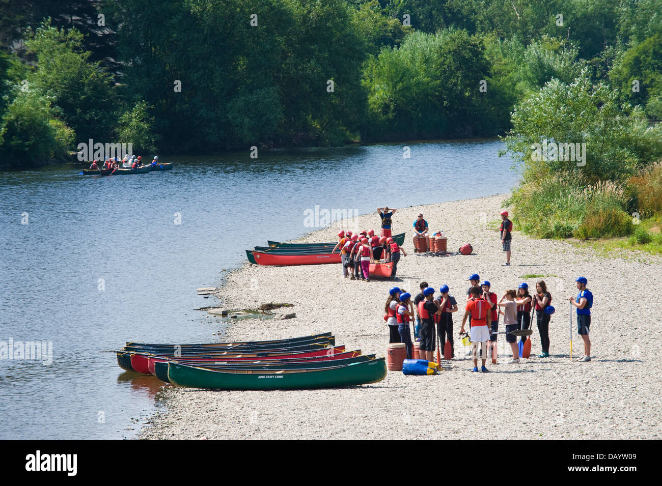 Groups of children receiving instruction in paddling open canoes on ...