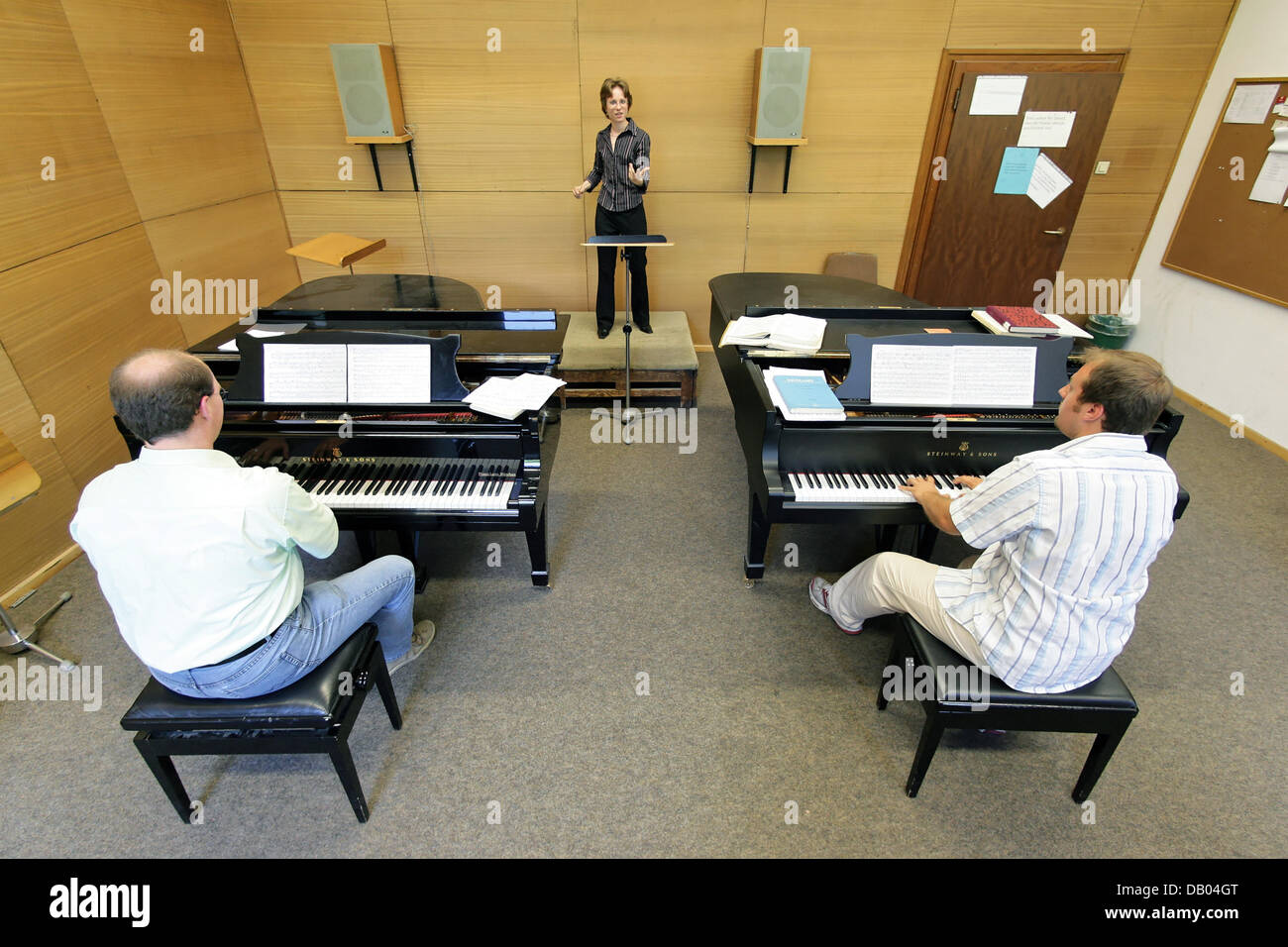 Anna Hauer (C) conducts two pianist during her entrance test as ...
