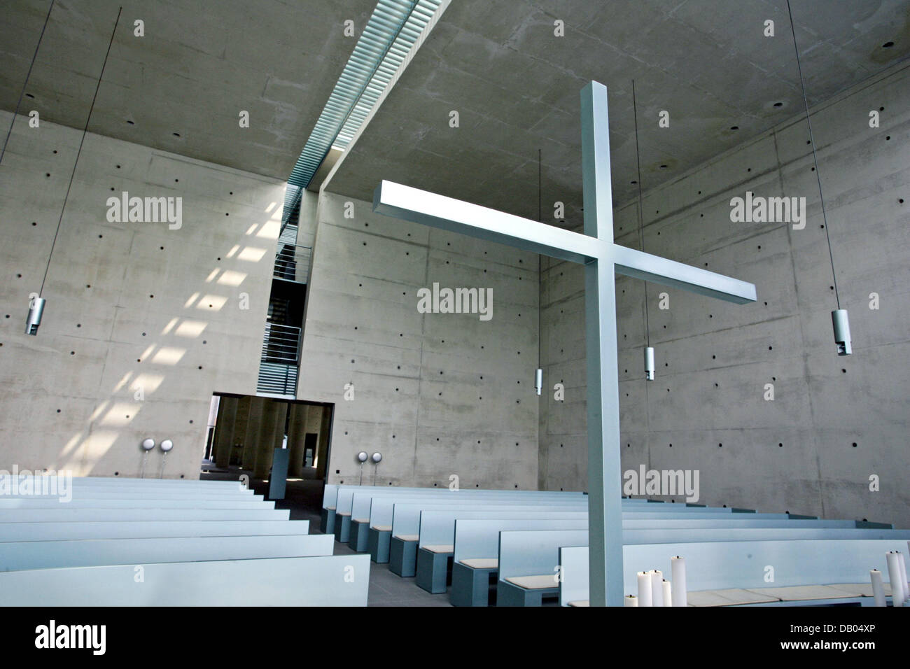 The photo depicts a mourning hall with benches and a large crucifix at ...