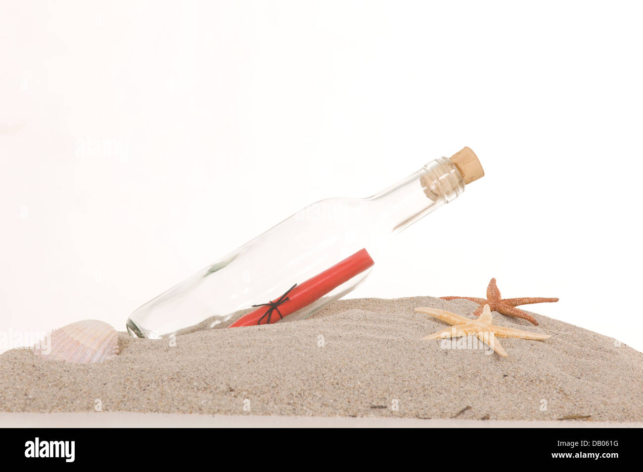 Glass bottle with note inside on sand, on white background Stock Photo ...