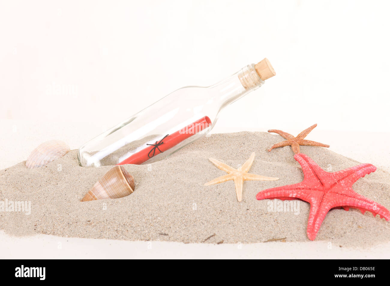 Glass bottle with note inside on sand, on white background Stock Photo ...