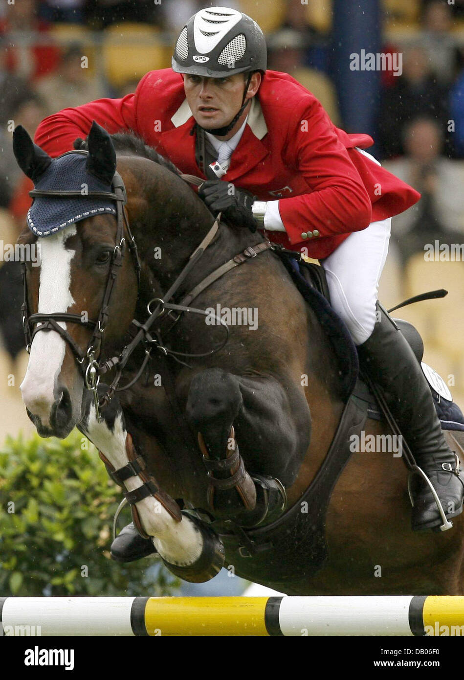 Swiss equestrian Werner Muff and his horse 'Plot Blue' take an obstacle ...