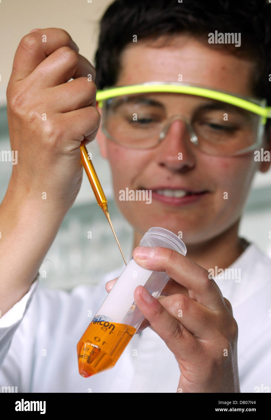 A food chemist sucks up liquid into a pipet for an analysis of frying ...