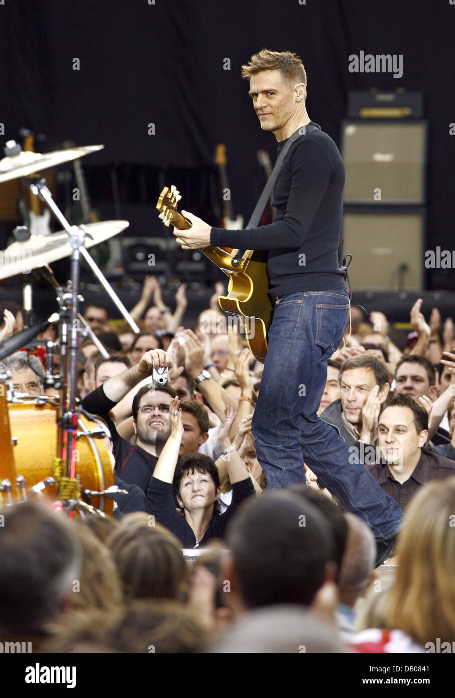 Canadian singer Bryan Adams performs with a golden guitarre on a stage ...
