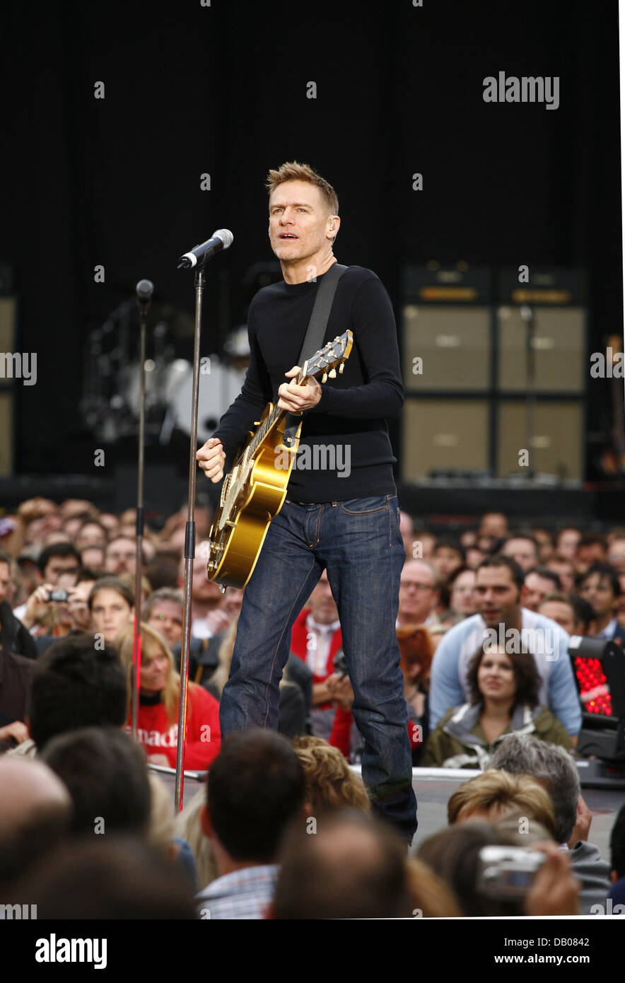 Canadian singer Bryan Adams performs with a golden guitarre on a stage ...