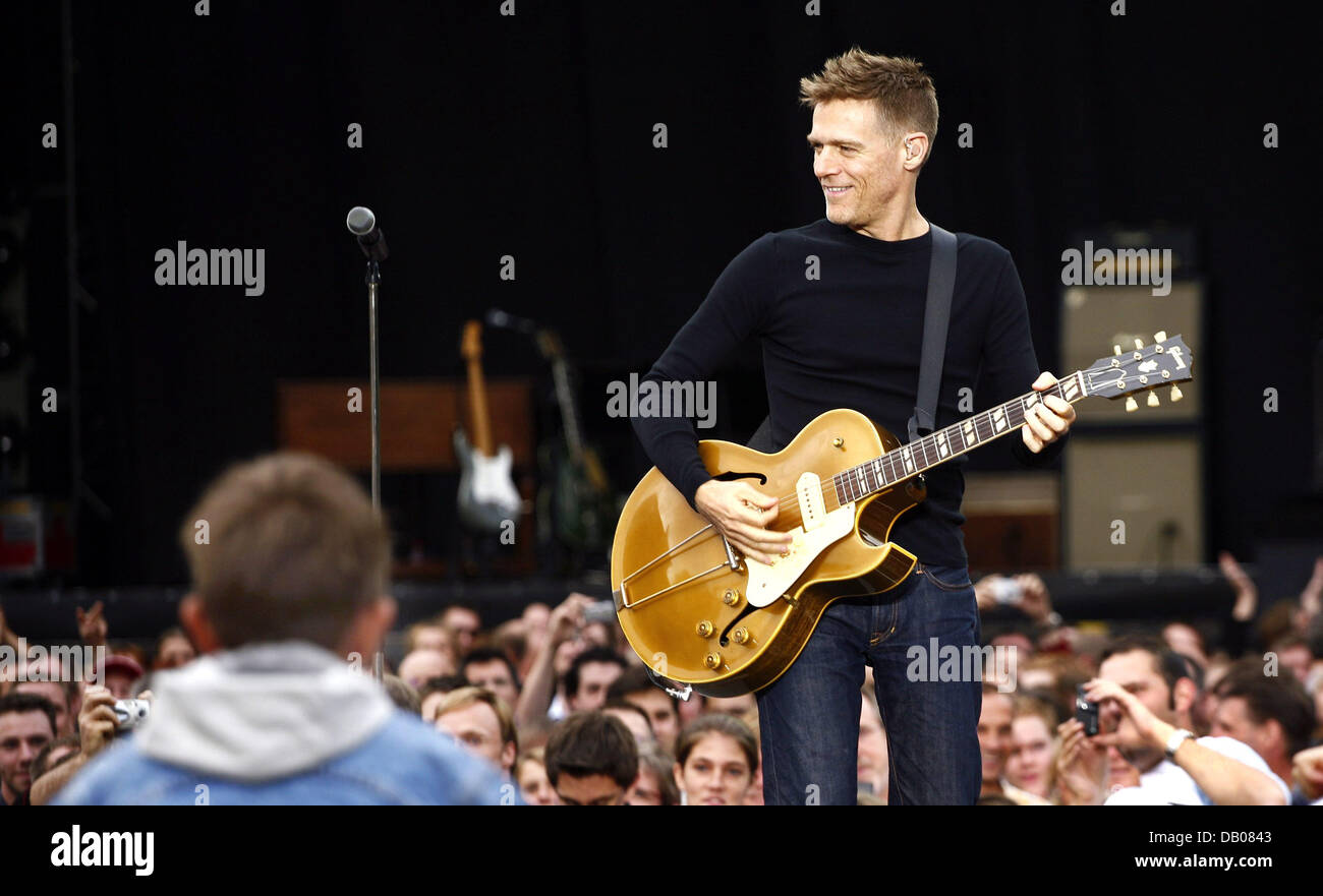 Canadian singer Bryan Adams performs with a golden guitarre on a stage ...