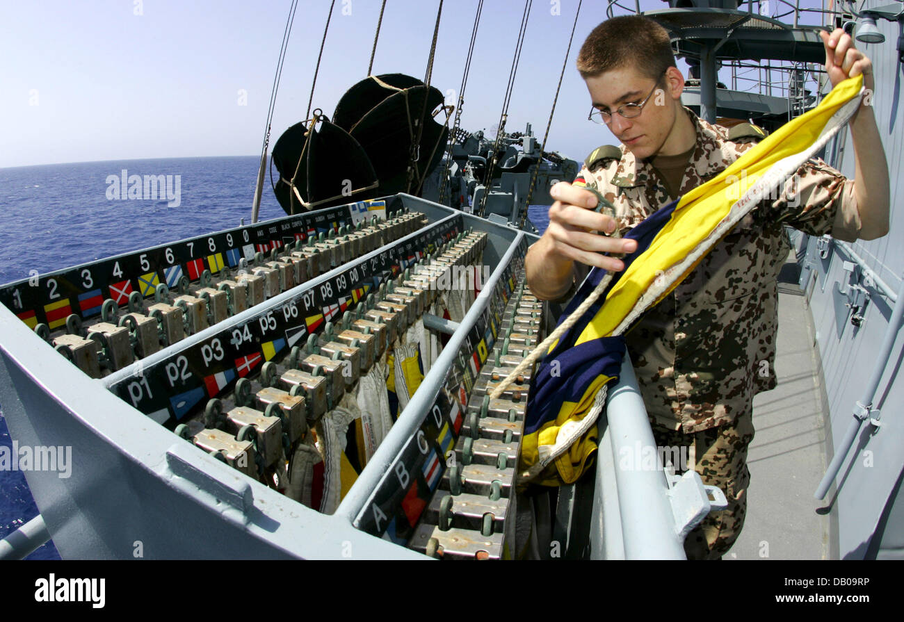A soldier of the German Navy sorts the flags on frigate 'Schleswig ...