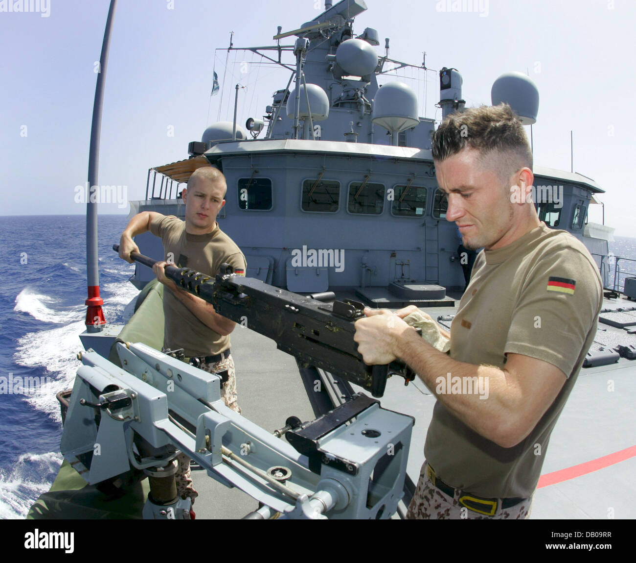 German Navy soldiers clean a gun on frigate 'Schleswig-Holstein' off ...
