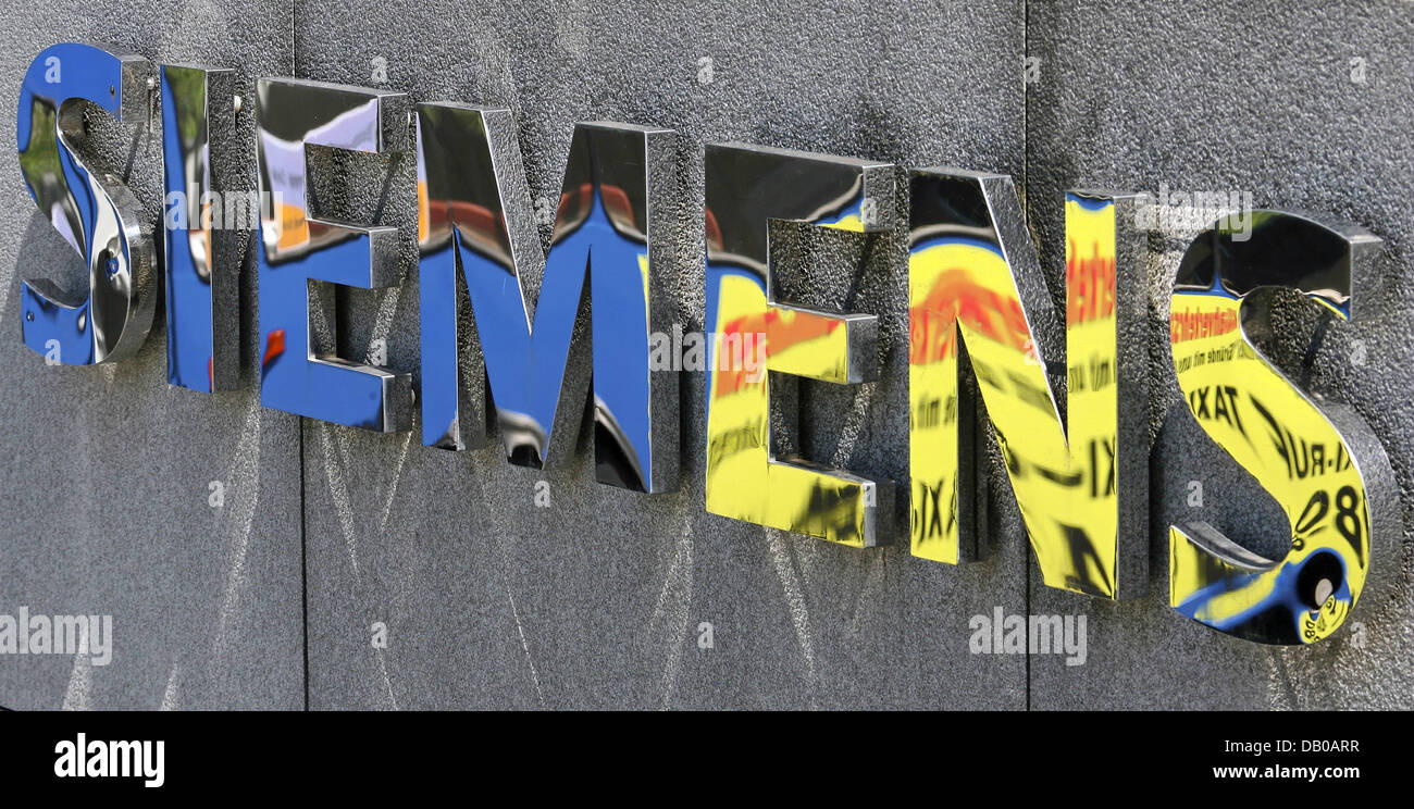 The colours of passing cars are reflected in the logotype of Siemens in ...
