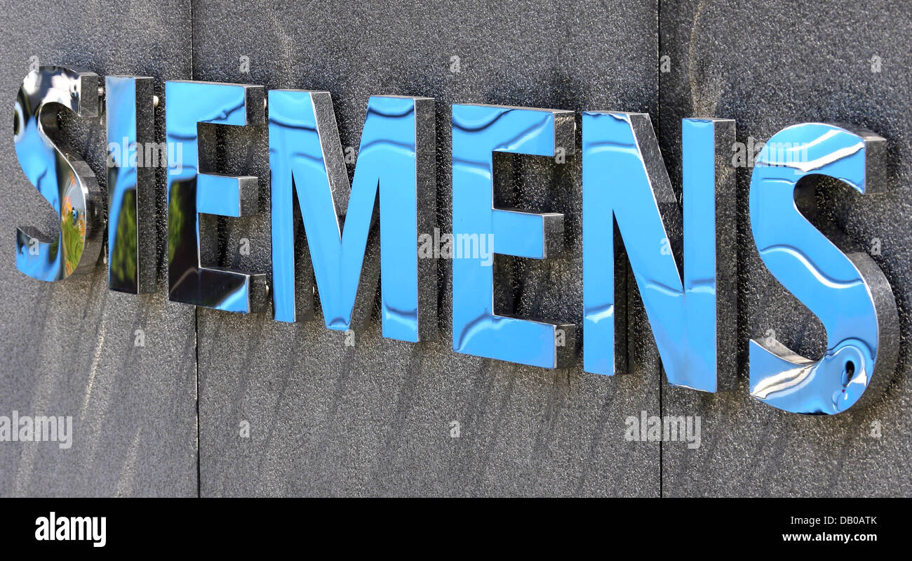 The colours of passing cars are reflected in the logotype of Siemens in ...