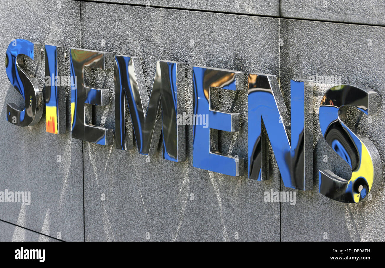 The colours of passing cars are reflected in the logotype of Siemens in ...