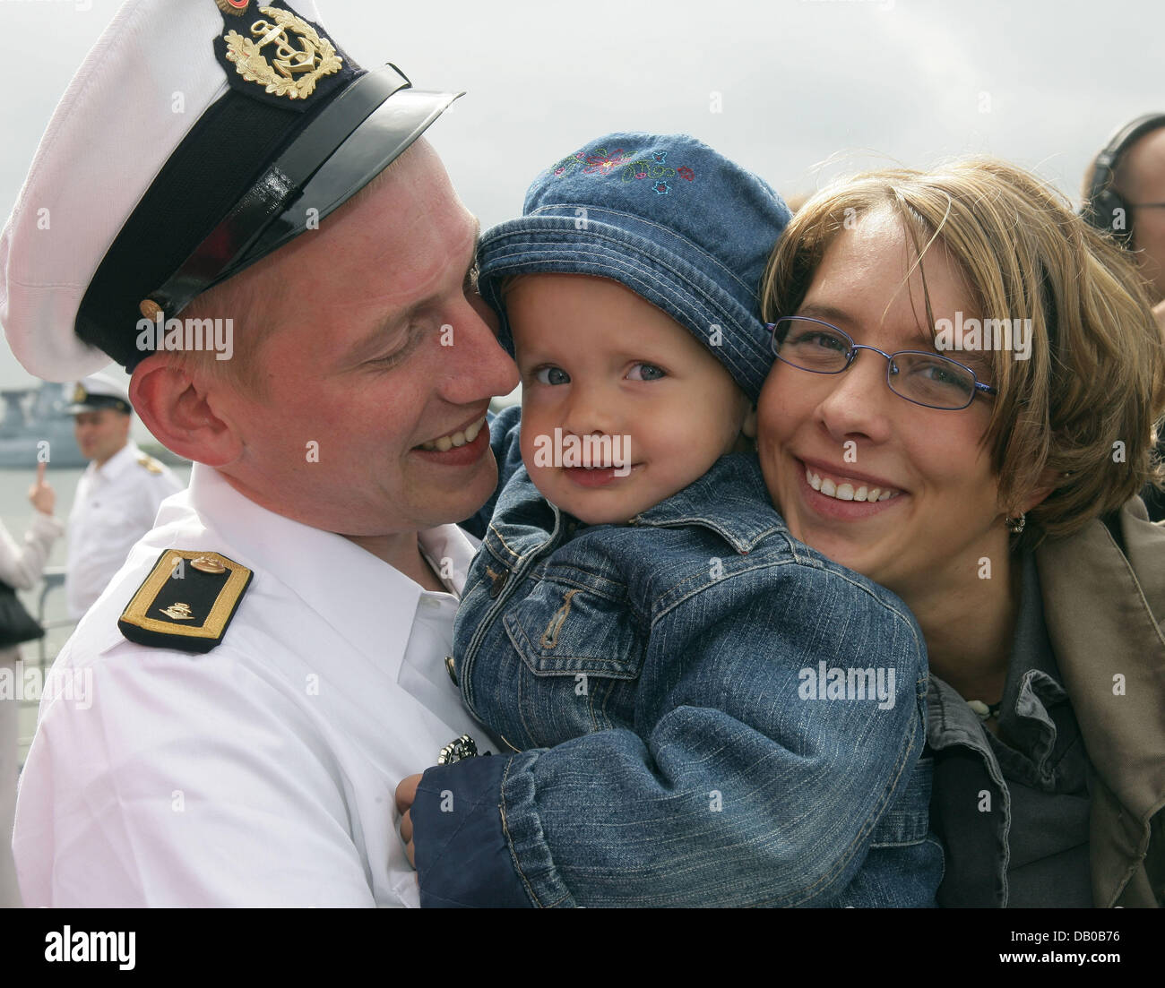 Petty Officer Second Class Jan Grabe hugs his wife Melanie and his two ...