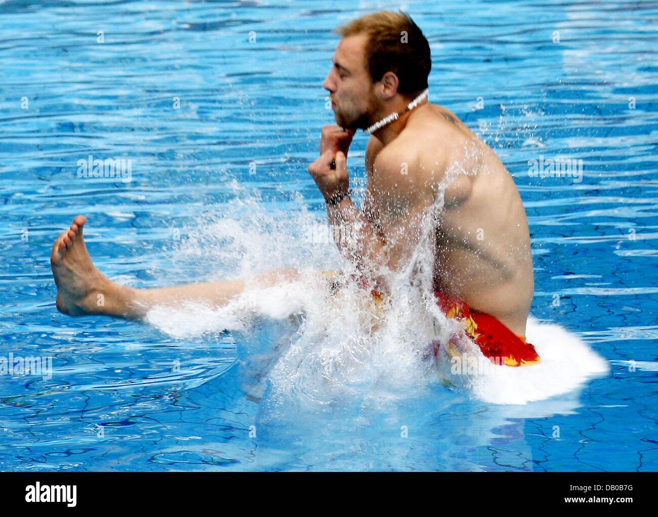 A participant of the Synchron competition hits the surface of the water ...