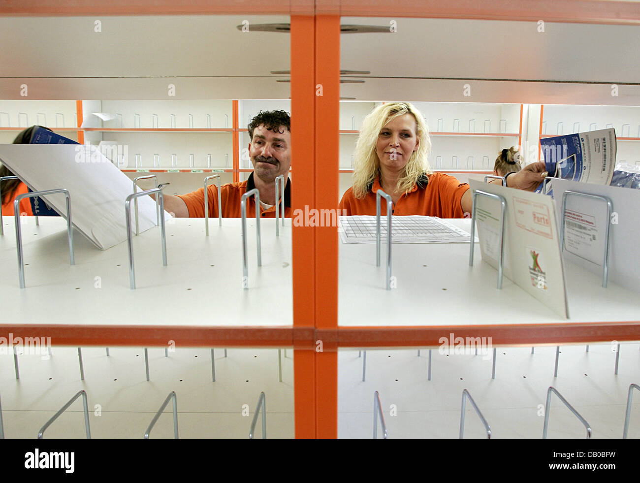 Postmen of TNT Postal Service sort letters at their desks in Bochum ...