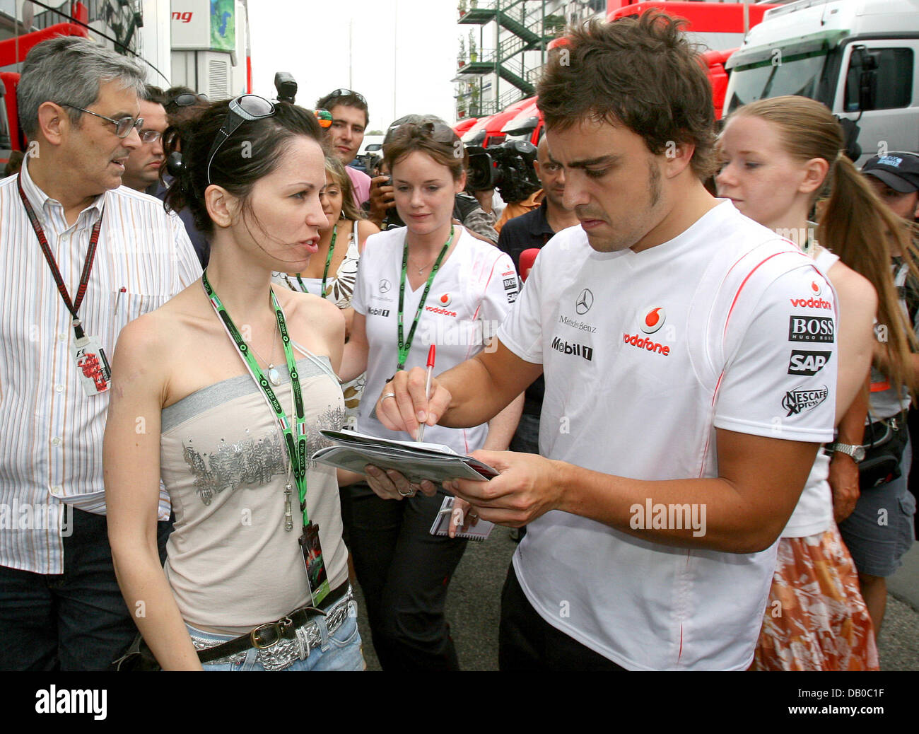 Spanish Formula One driver Fernando Alonso of McLaren Mecedes (R) sings ...