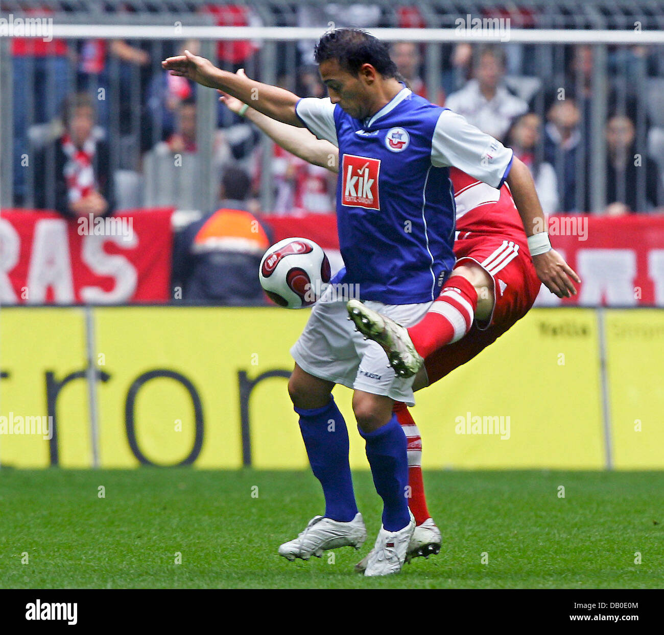 Munich's Bastian Schweinsteiger (BACK) vies for the ball with Rostock's ...